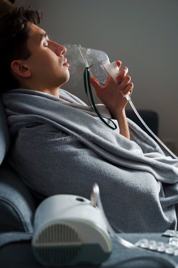 Man Inhaling through Oxygen Mask for Cough Treatment. Using Compressor ...