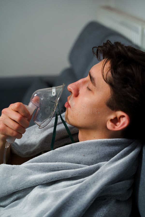 Man Inhaling through Oxygen Mask for Cough Treatment. Using Compressor ...