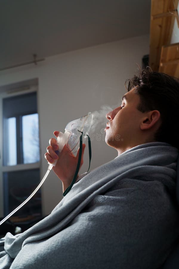 Man Inhaling through Oxygen Mask for Cough Treatment. Using Compressor ...