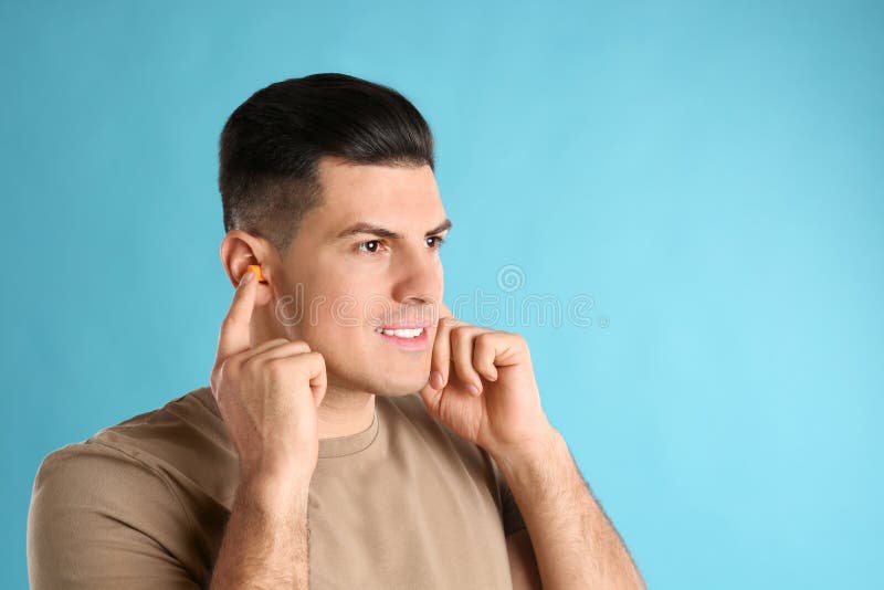 Man Inserting Foam Ear Plugs in Bed, Closeup Stock Photo - Image of ...
