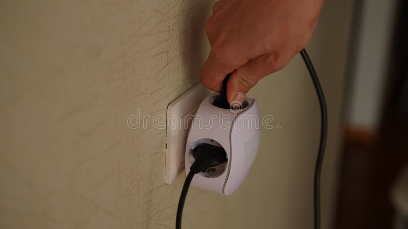 Man Inserting Two-pin Plug into White Electrical Tee Adapter Plugged ...