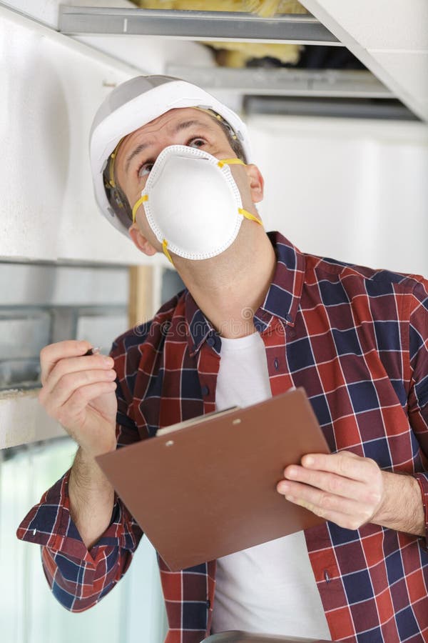 Man Inspecting Property on Ladder Wearing Dust Mask Stock Image - Image ...
