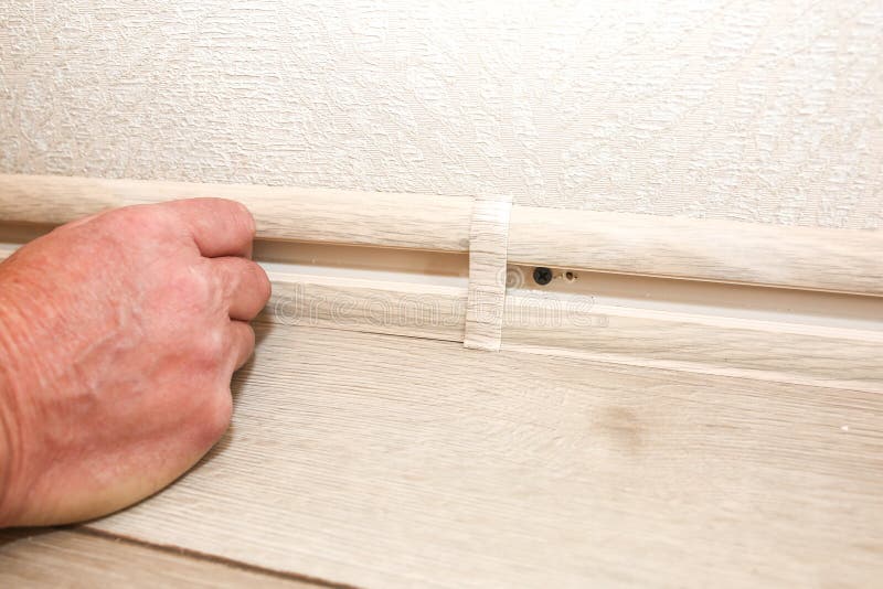 Man is Installing the Baseboard. Repair Works Indoors Stock Photo ...