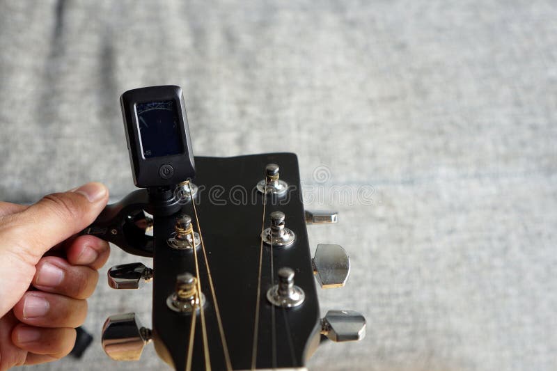 A Man is Installing a Digital Tuner Device on a Guitar Stock Image ...