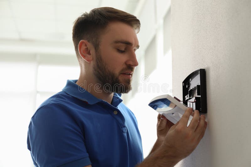 Man Installing Home Security System on White Wall in Room Stock Photo ...