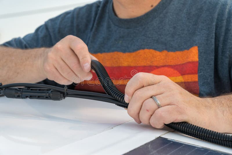 Man Installing a Split Wire Loom Conduit for a Solar Panel Wire ...