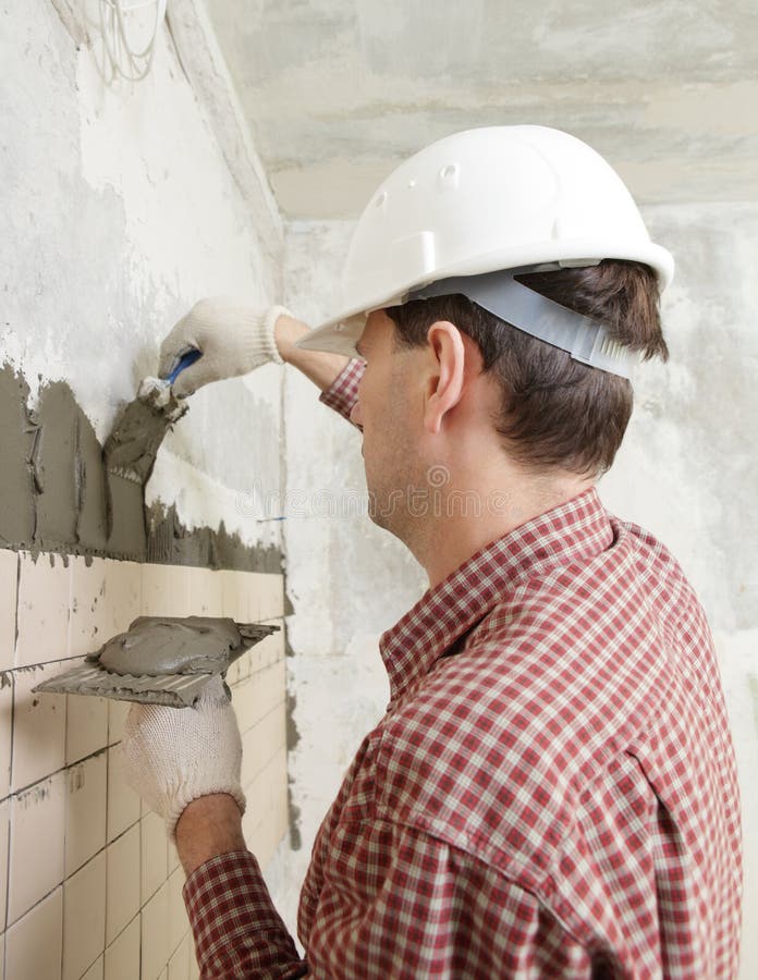 Man installs ceramic tile stock image. Image of occupation - 10601493