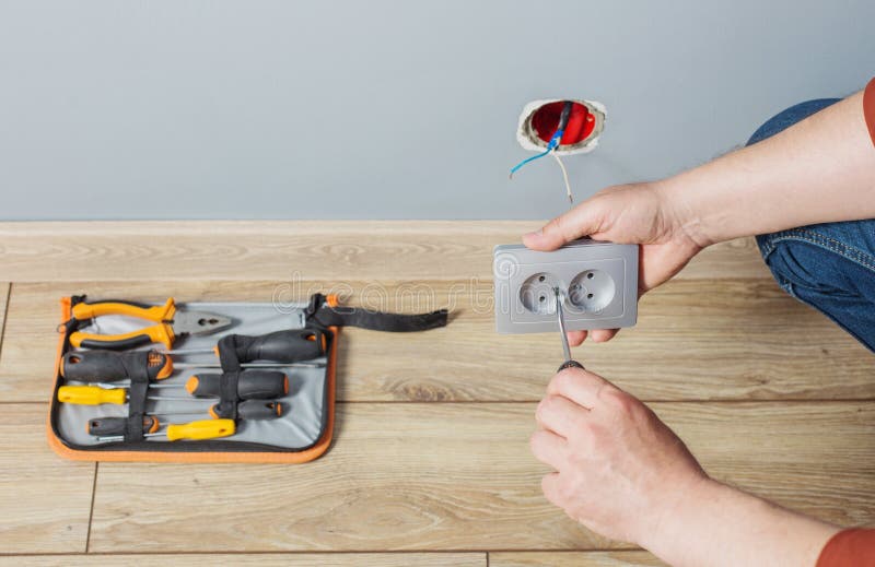 Man Installs an Electrical Outlet on Gray Wall Stock Image - Image of ...