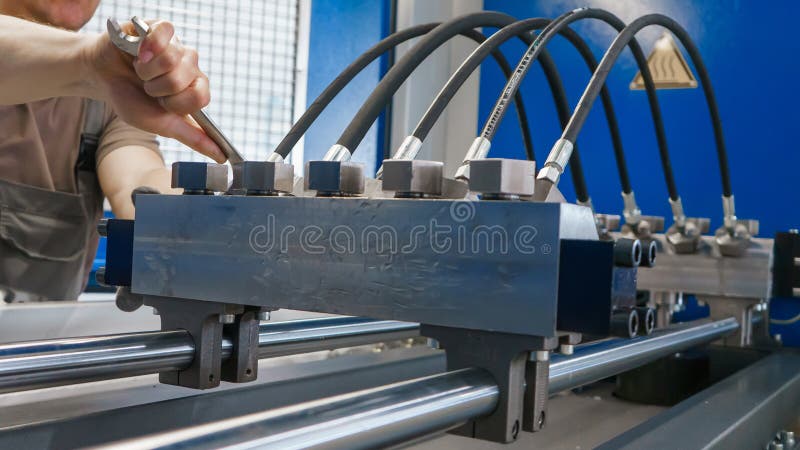 A Man Installs High Pressure Hoses into a Testing Machine. Product ...