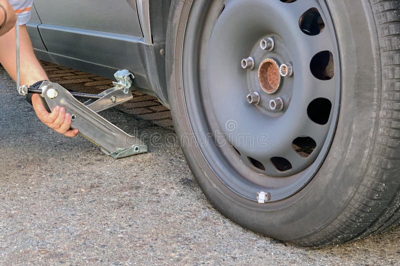 Man Installs a Jack To Replace a Flat Car Tire Stock Image - Image of ...