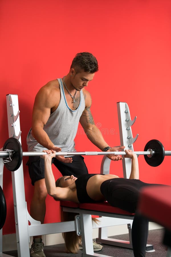 Man Insures Girl during she Training with Barbell Stock Photo - Image ...
