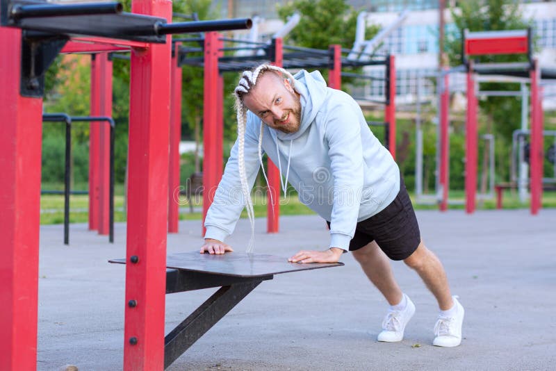 A Man with an Interesting Mohawk Hairstyle Doing Push-ups on the Street ...