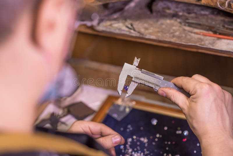 A Man Jeweler Makes an Accurate Measurement of a Gem Using a Caliper ...