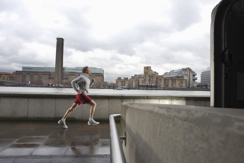 Man Jogging on Bridge Against Building Stock Photo - Image of leisure ...