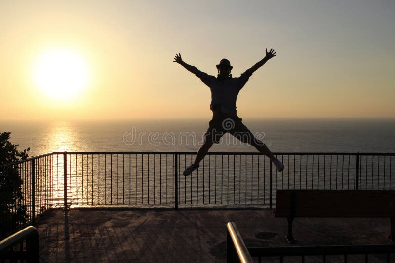 Man Jumping in Front of the Water during a Sunset Stock Photo - Image ...
