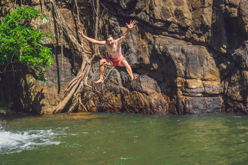 Man Jumping Off Cliff into the Water. Summer Fun Lifestyle Stock Image ...