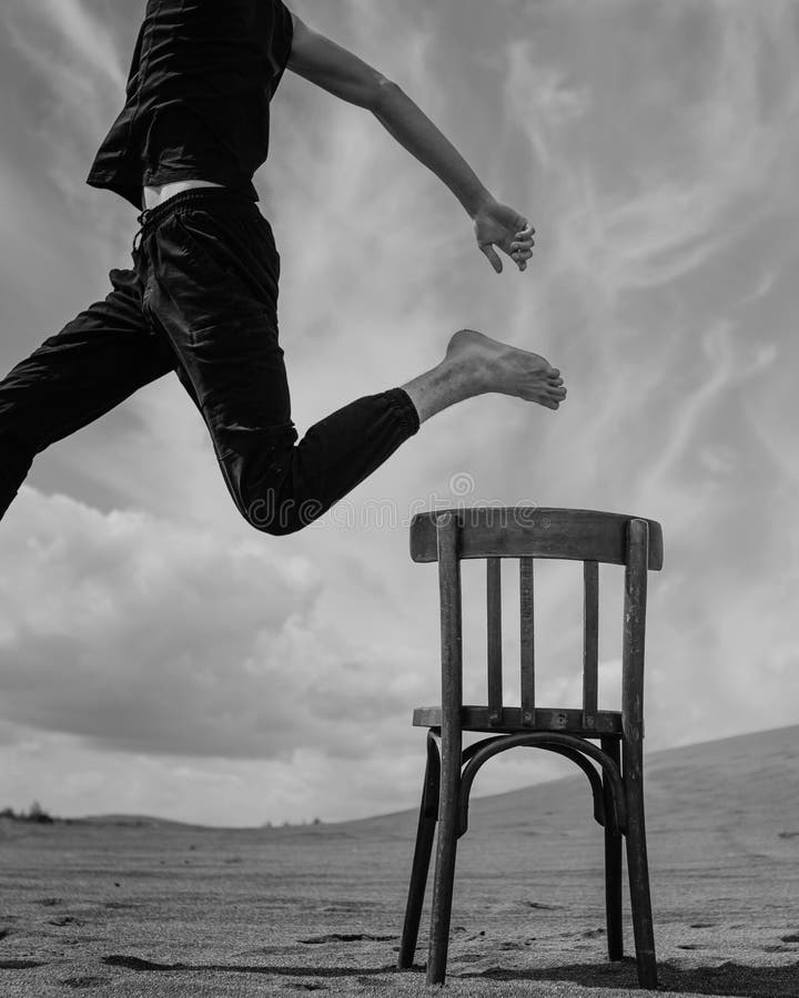 Man Jumping Over Chair in Desert Stock Photo - Image of chair, dune ...