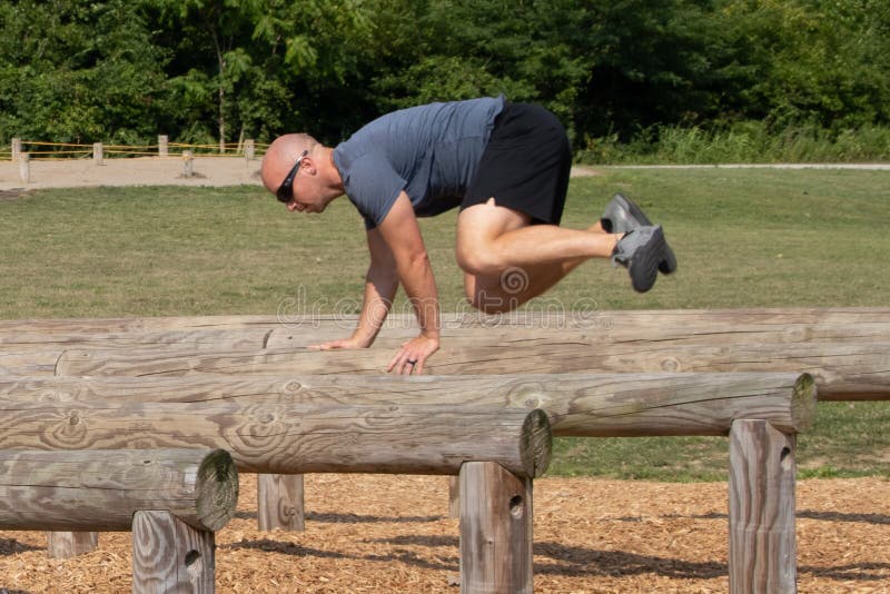 Man Jumping Over Logs on an Obstacle Course Stock Image - Image of jump ...