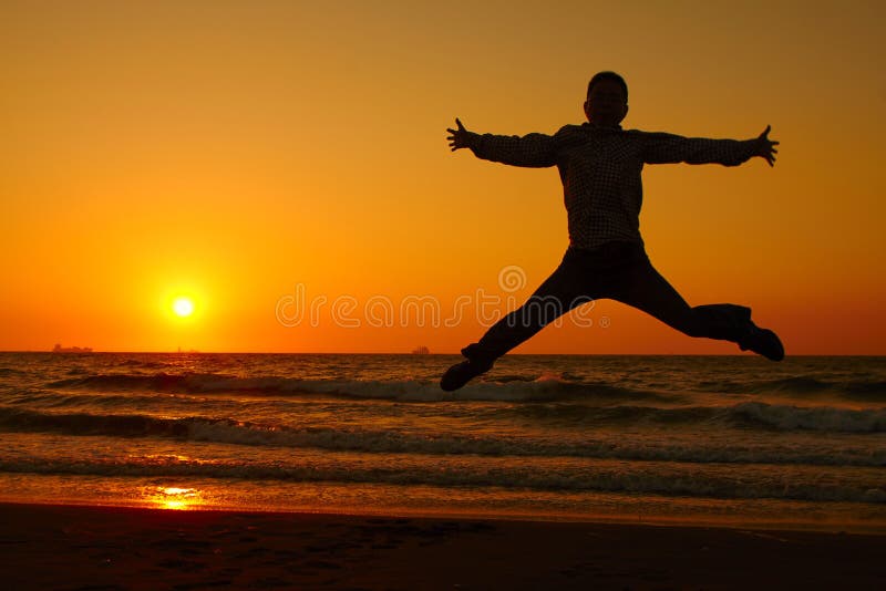 Man Jumping on Sunset Sky with Birds Flying at Top of Mountain and ...