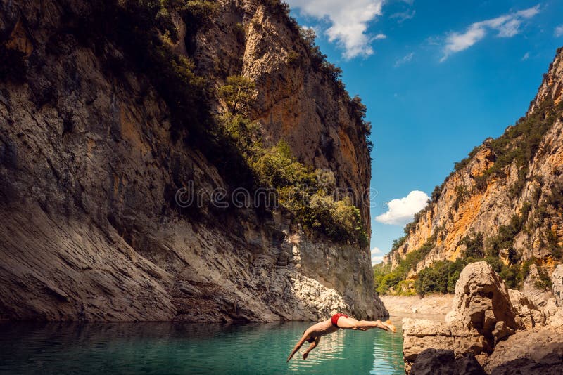 Man Jumping into the Water of a Gorge in the Pyrenees Mountains Stock ...