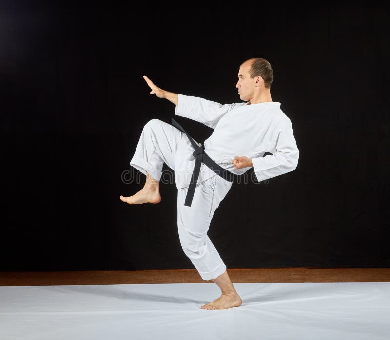 A Man in Karategi Beats a Kick Leg on a Black Background Stock Image ...