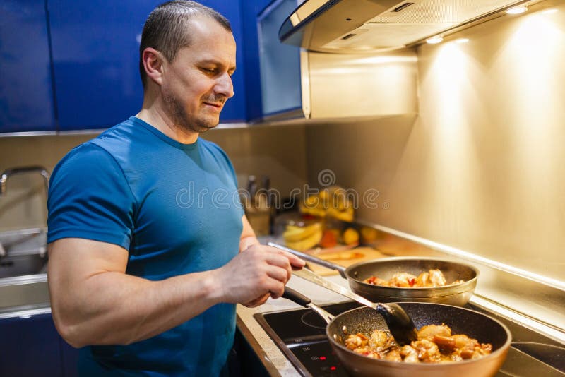 Man in the Kitchen is Cooking at Home at the Wok Stock Photo - Image of ...