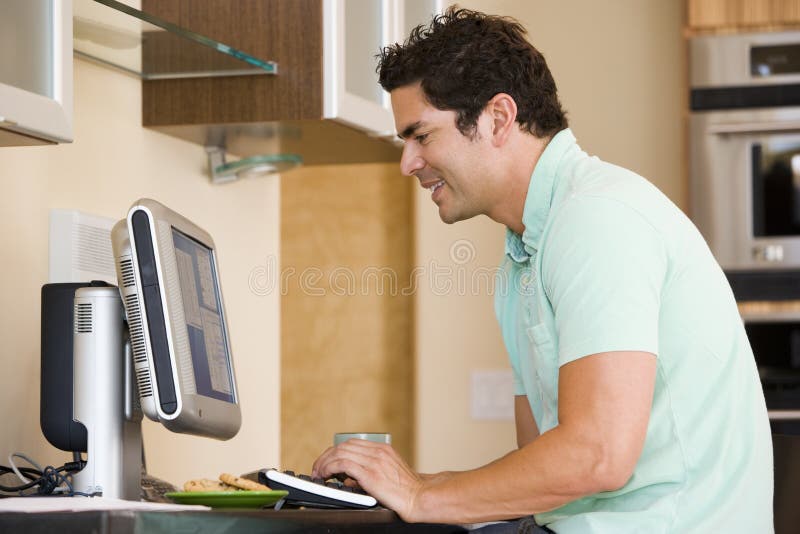 Man in Kitchen Using Computer and Smiling Stock Photo - Image of young ...