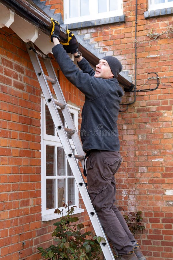Man on a Ladder Fixing Rain Gutter on a UK House Stock Photo - Image of ...
