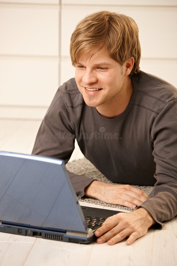 Smiling Guy Using Laptop Computer Stock Photo - Image of adult, indoors ...
