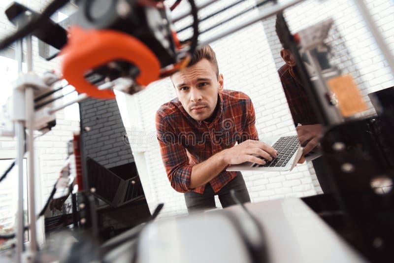A Man with a Laptop in His Hands Controls the Process of Printing a 3d ...