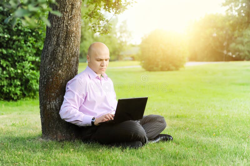 Man with Laptop Sitting Near a Tree Stock Photo - Image of laptop ...