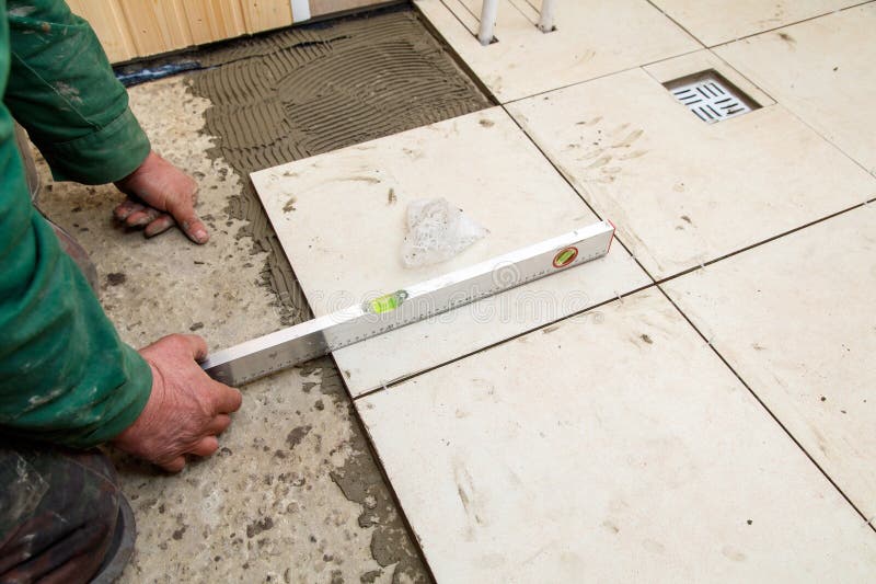 A Man is Laying Down a Tile Floor Stock Image - Image of renovation ...