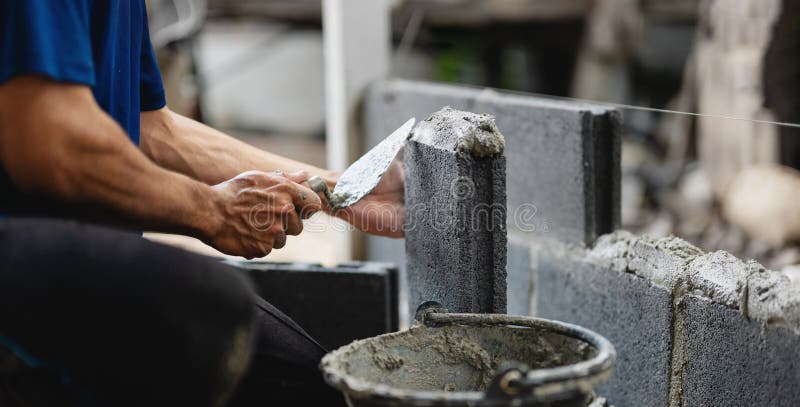 Man is Laying on the Ground and Using a Trowel To Spread Stock Photo ...