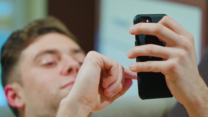 Man Laying on the Sofa and Using Mobile Phone Stock Image - Image of ...