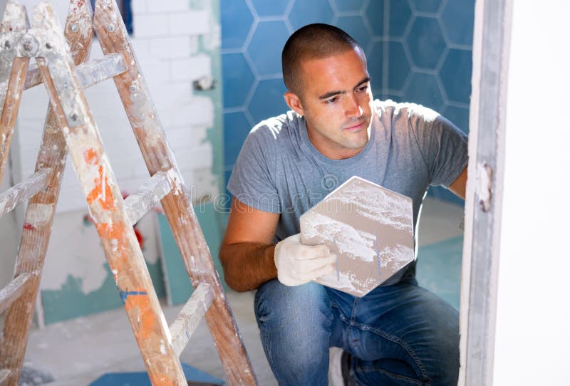 Man Laying Tile in Bathroom Stock Photo - Image of german, male: 257192822