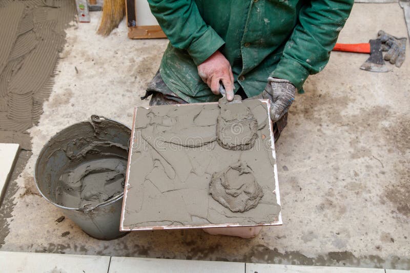 A Man is Laying a Tile on the Floor Stock Photo - Image of building ...