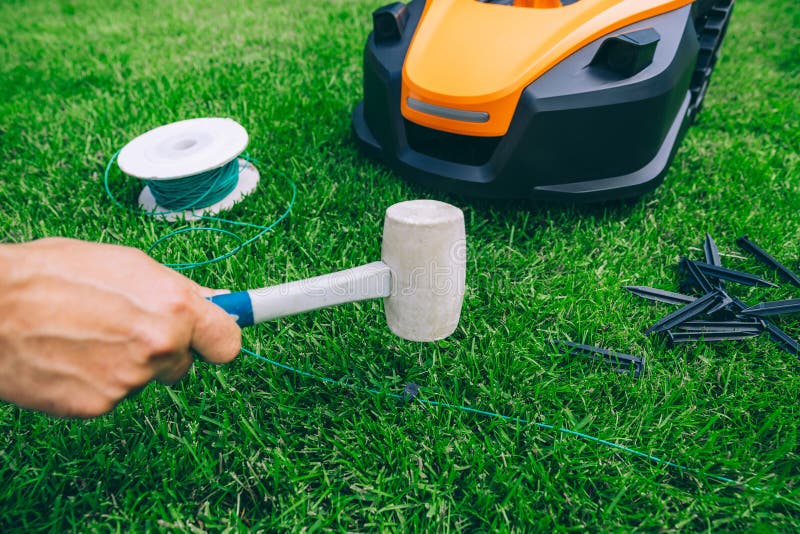 Man Lays a Cable and Hammers in a Plastic Peg for Autonomous Operation ...