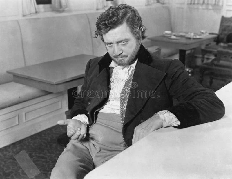Man Leaning Against a Counter in a Restaurant with a Ring in His Hand ...