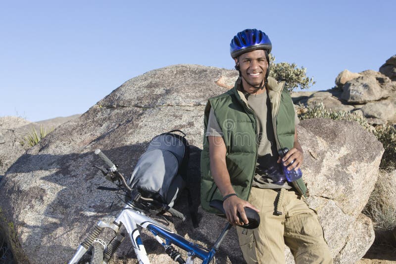 Man Leaning Against Rock with Mountain Bike Stock Photo - Image of ...