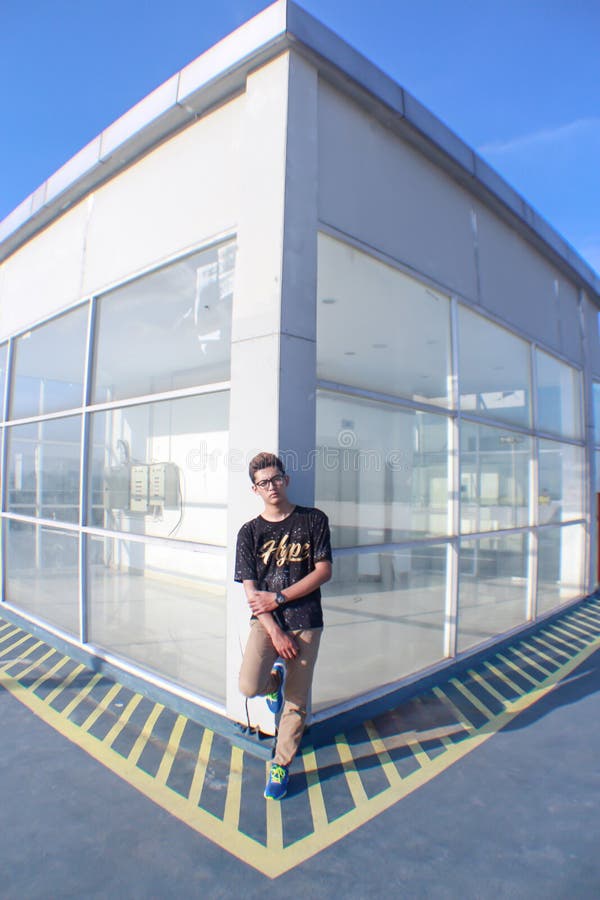 Man Leaning on Corner of Building with Glass Walls Stock Photo - Image ...