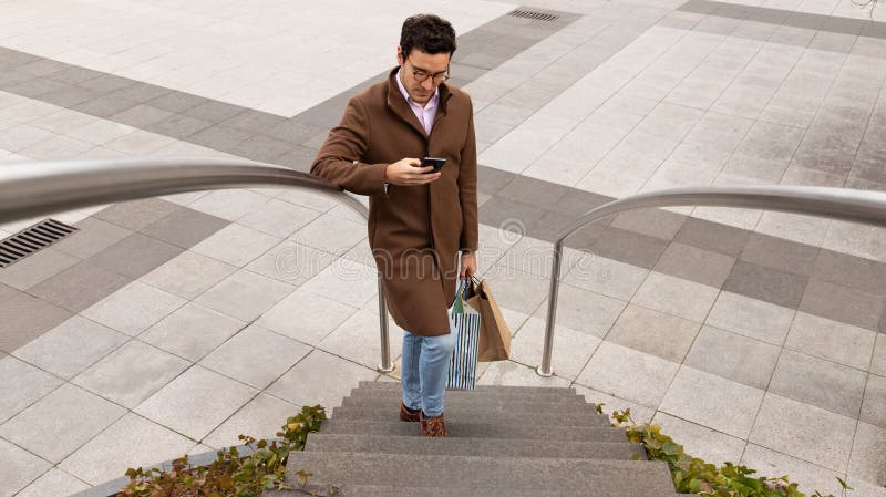 Man Leaning on the Railing of Some Stairs Using the Mobile Stock Photo ...
