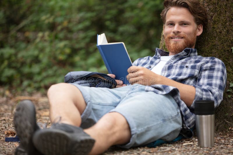 Man sitting against tree stock photo. Image of relaxed - 21963692