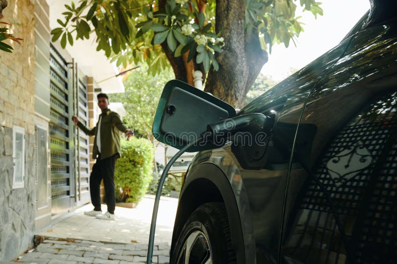 Man Leaving Car Charging stock image. Image of supply - 320287307