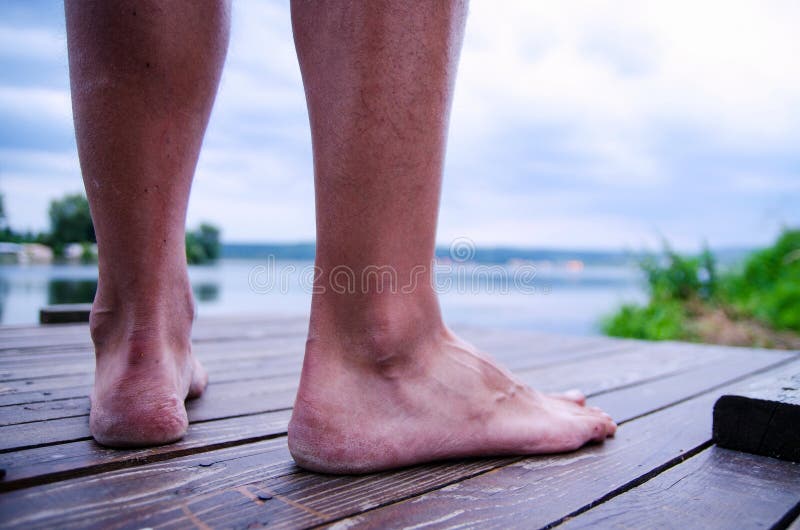 Man Legs Standing on a Dock while Relaxing on Seaside. Stock Image ...