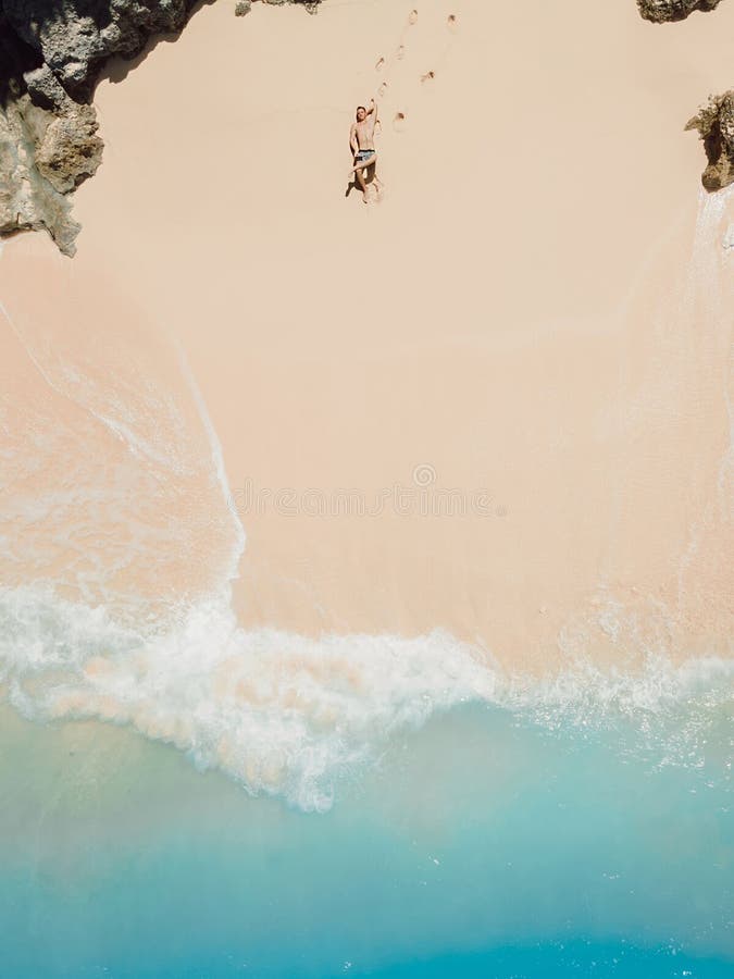 Man Lies and Sunbathing on the Sand at Tropical Ocean Beach. Drone View ...