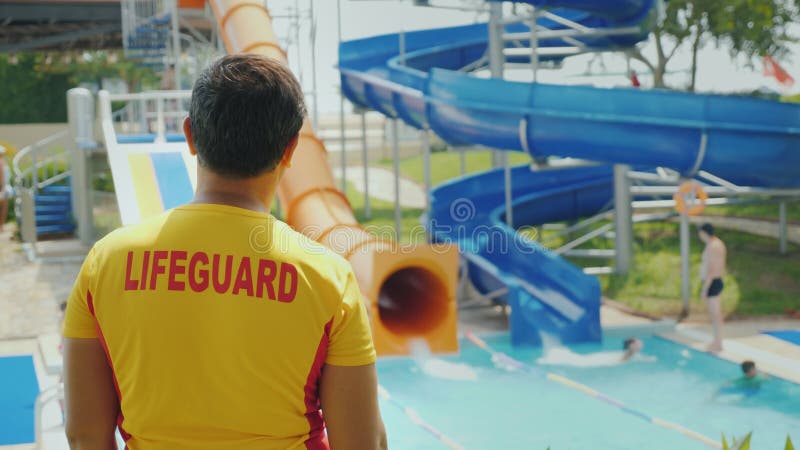 A Man Lifeguard is on Duty Near Water Slides Stock Video - Video of ...
