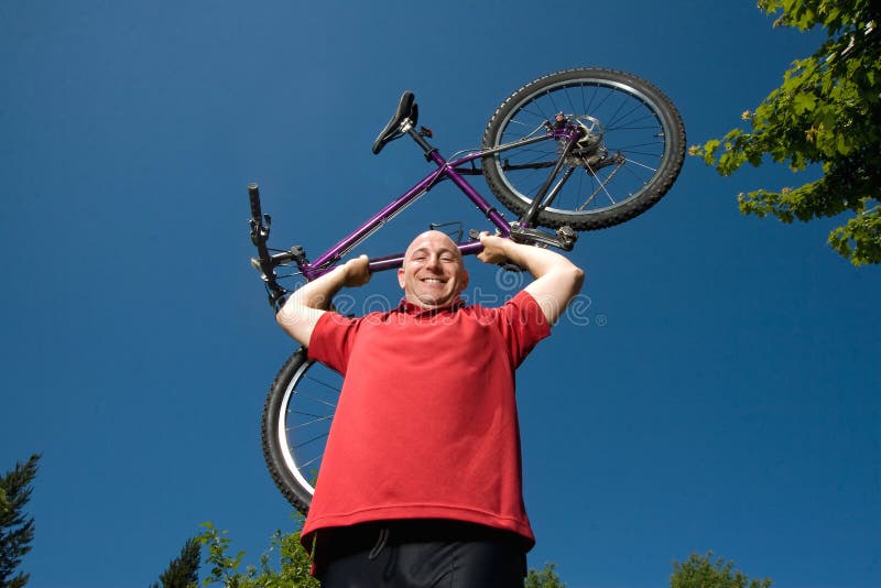 Man Lifting Bicycle Over Head Smiling - Horizontal Stock Photo - Image ...