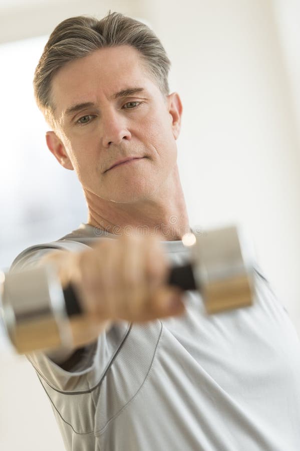 Man Lifting Dumbbell at Gym Stock Image - Image of building, looking ...