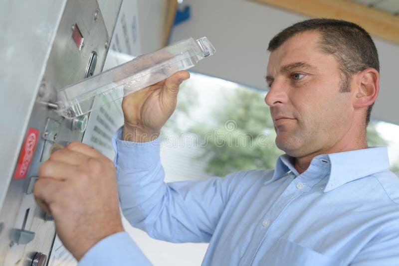 Man Lifting Flap on Machine To Put Money into Slot Stock Image - Image ...