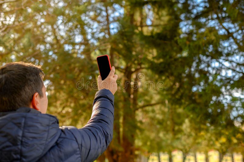 Man Lifts a Cell Phone in Nature. Concept of Wifi Connection, Internet ...